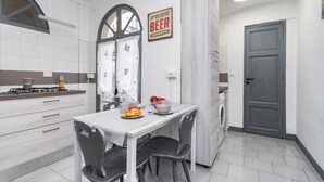 Cozinha moderna com mesa de jantar, cadeiras, fogão e um aviso oferecendo cerveja grátis amanhã.