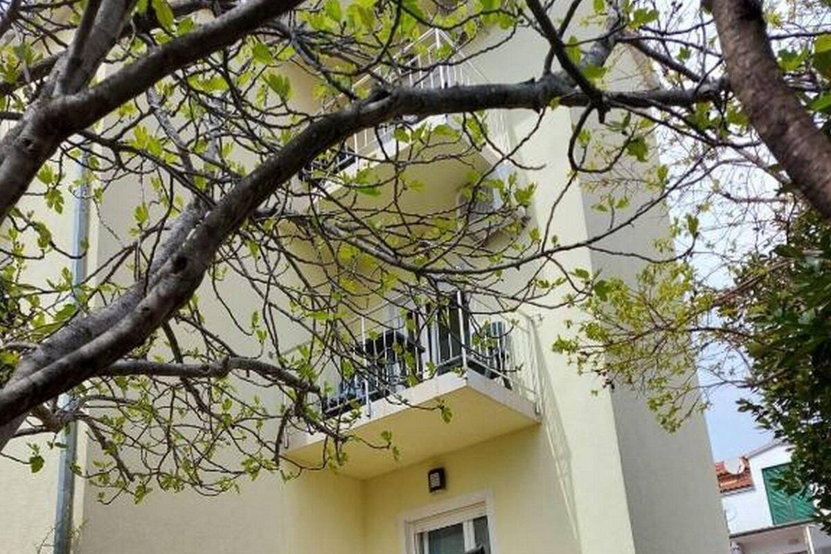 Uma mesa com quatro cadeiras em frente a um edifício com varanda.