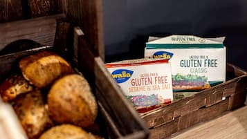 Caixa de madeira com pão Wasa sem glúten e embalagens de Wasa sem lactose e sem glúten, sabor sementes de sésamo e flor de sal.