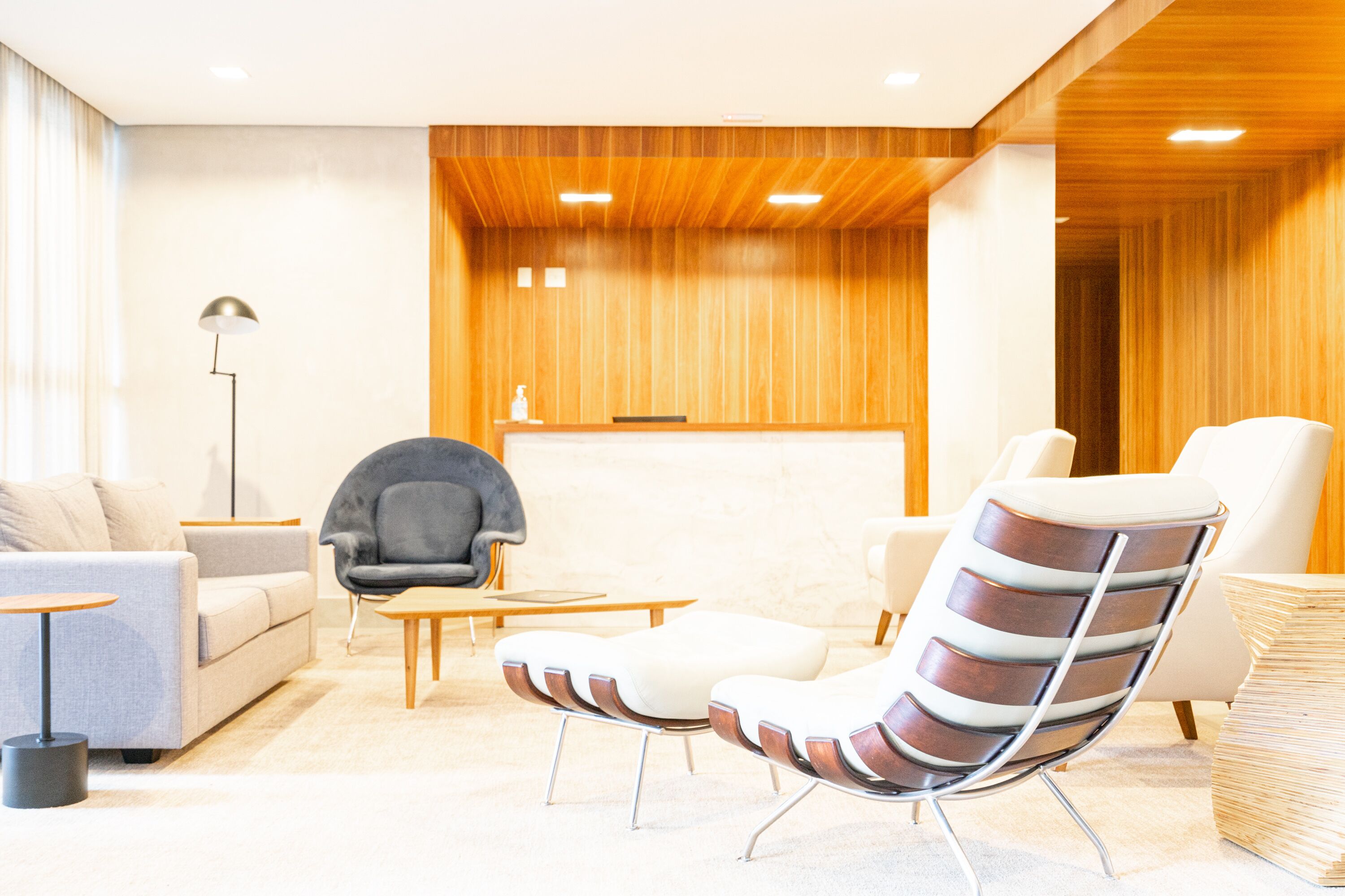 Uma sala de estar moderna com um sofá, poltronas e uma mesa de centro.