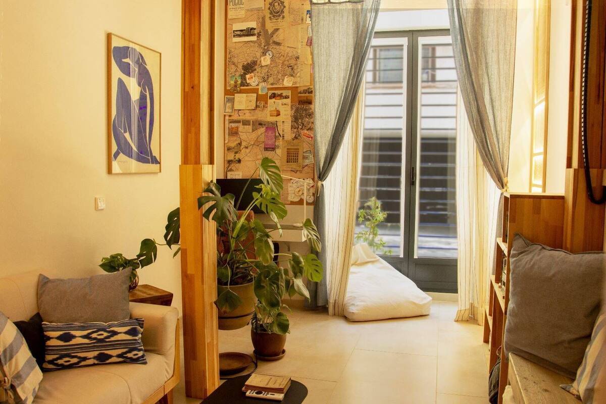 Uma sala de estar aconchegante com um sofá, uma mesa de centro e um vaso de planta.