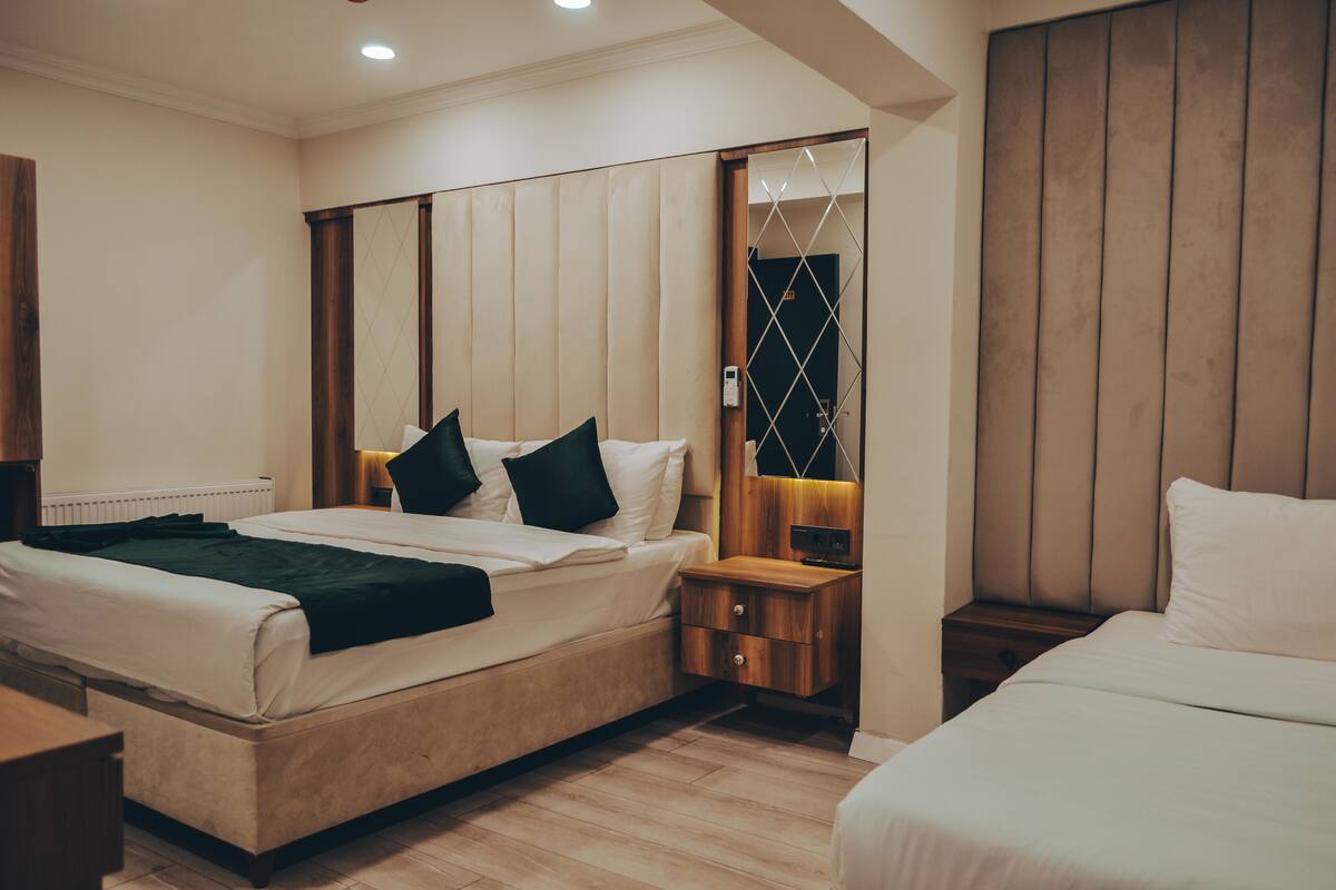 Quarto moderno com uma cama grande, mesas de cabeceira e cabeceira de madeira.
