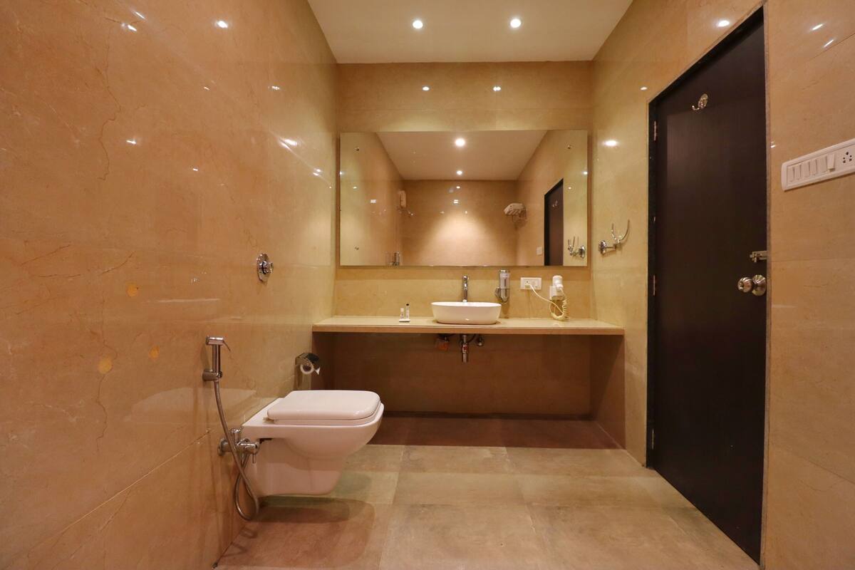Uma casa de banho moderna com sanita, lavatório e chuveiro.