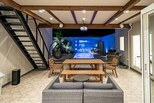 Uma sala de estar moderna com uma mesa de madeira, sofá e escada.