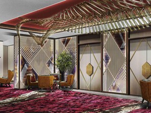 Quarto com parede estampada, planta e tapete vermelho.