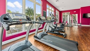 Uma academia com esteiras, elípticos e outros equipamentos de ginástica.