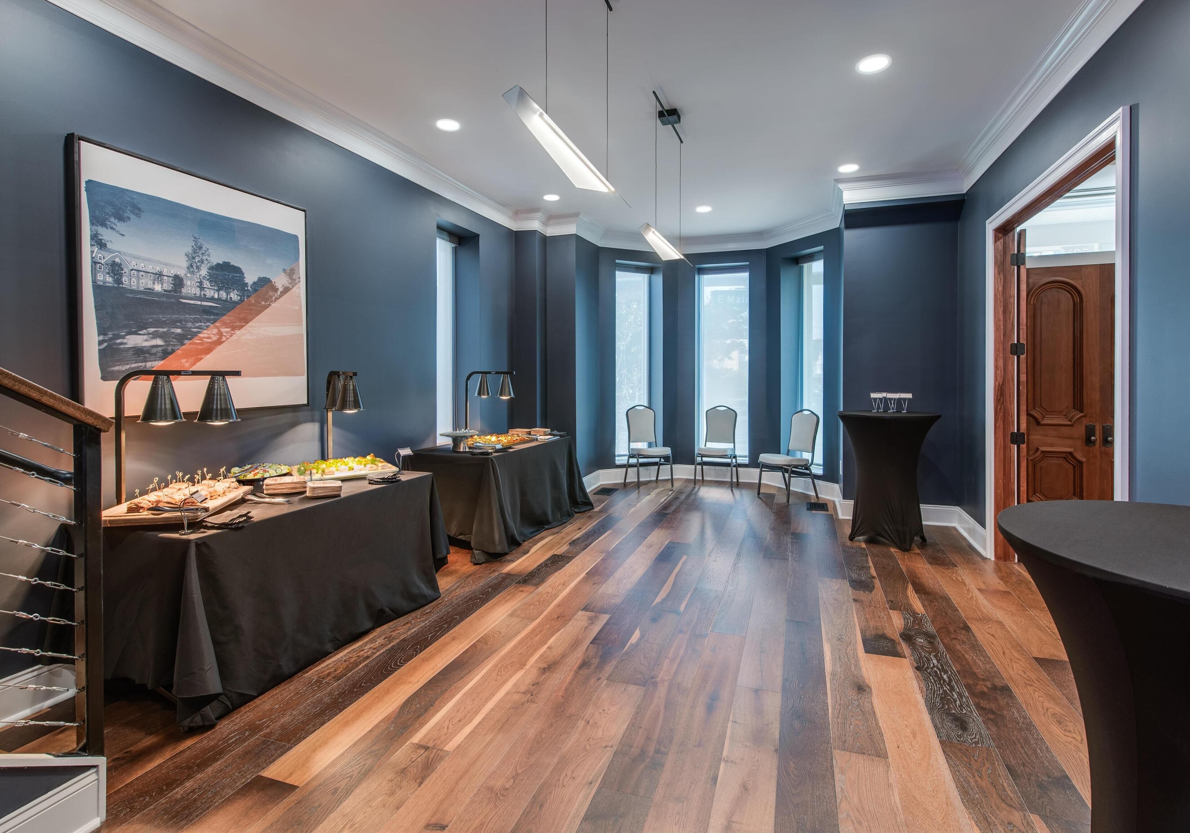 Sala de conferências com uma mesa comprida, cadeiras e um serviço de buffet.