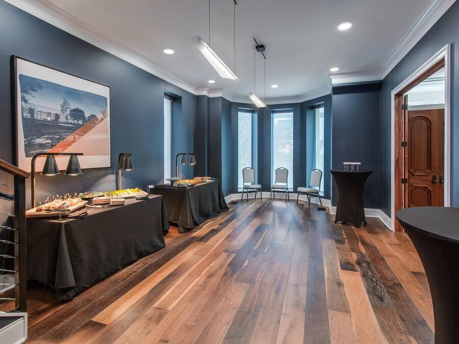 Sala de conferências com uma mesa comprida, cadeiras e um serviço de buffet.