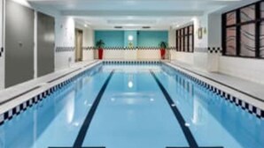 Piscina interior com faixas demarcadas e piso de azulejos.