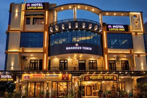 Um hotel chamado 'Lotus Inn' com uma placa grande 'Mahaveer Tower'.
