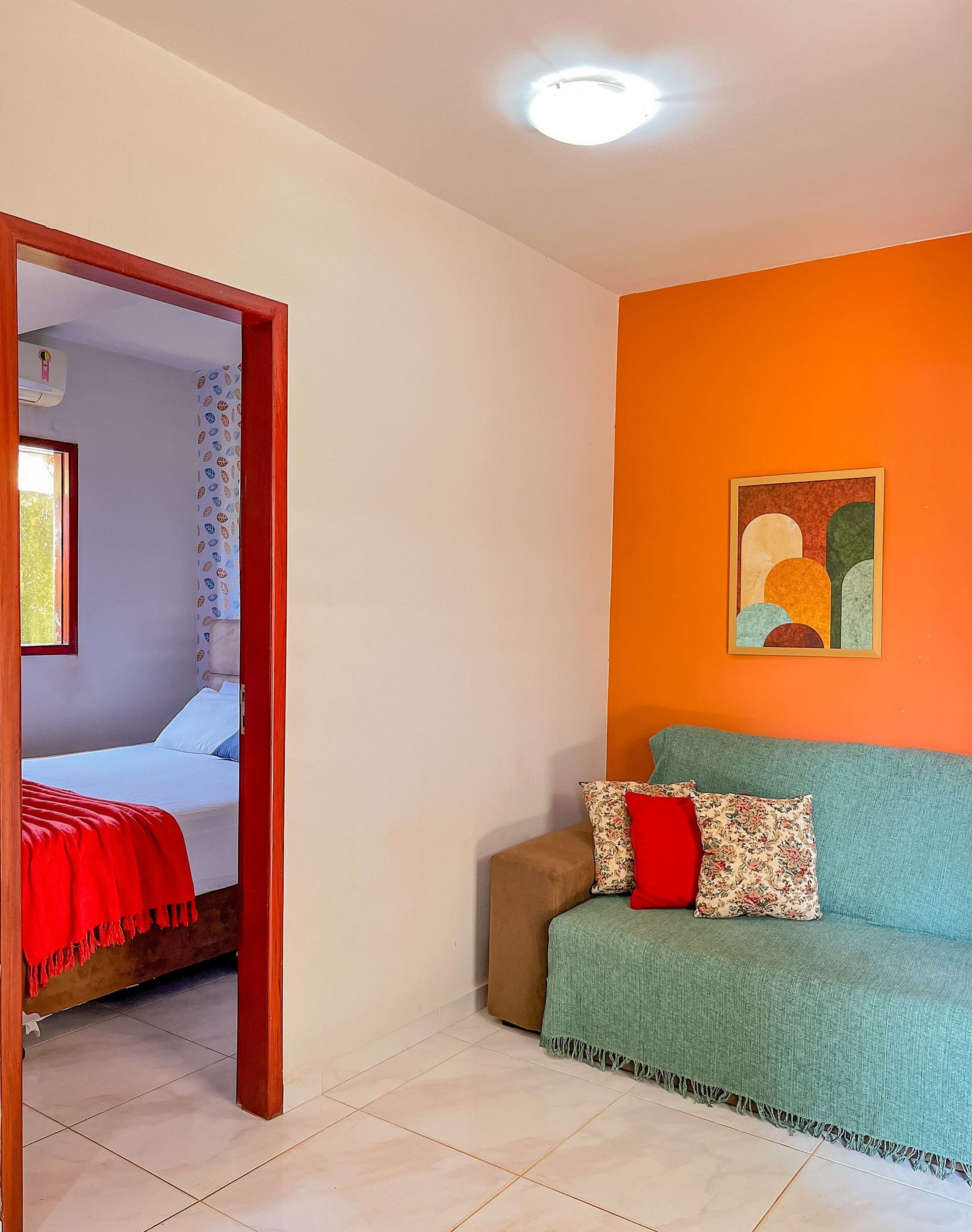 Um quarto com uma cama, um sofá e um quadro na parede.