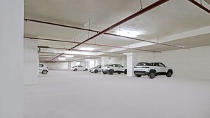 Uma garagem de estacionamento em vários níveis, com paredes brancas e pisos de concreto.