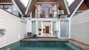 Uma casa moderna com piscina, varanda e vista para o interior.