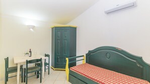 Quarto com cama, escrivaninha e guarda-roupa.