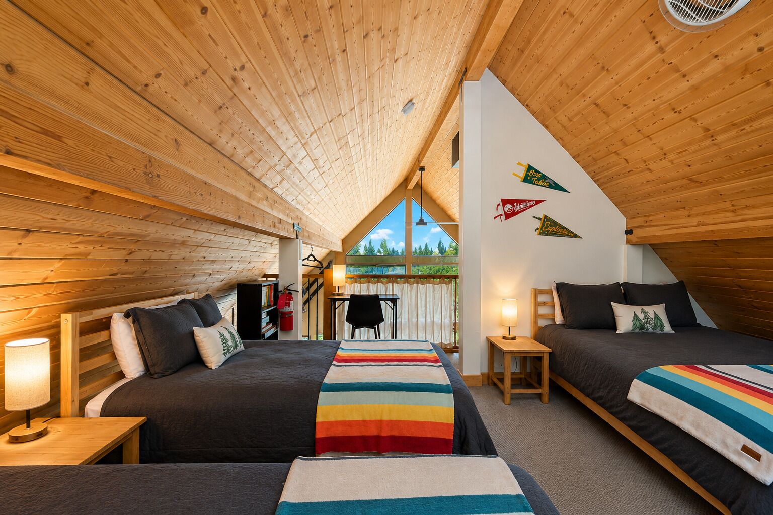 Quarto sótão acolhedor com duas camas, um espaço de refeições e vista para o exterior.