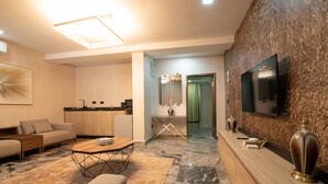 Uma sala de estar moderna com um sofá, mesa de centro e uma TV fixada numa parede com textura.