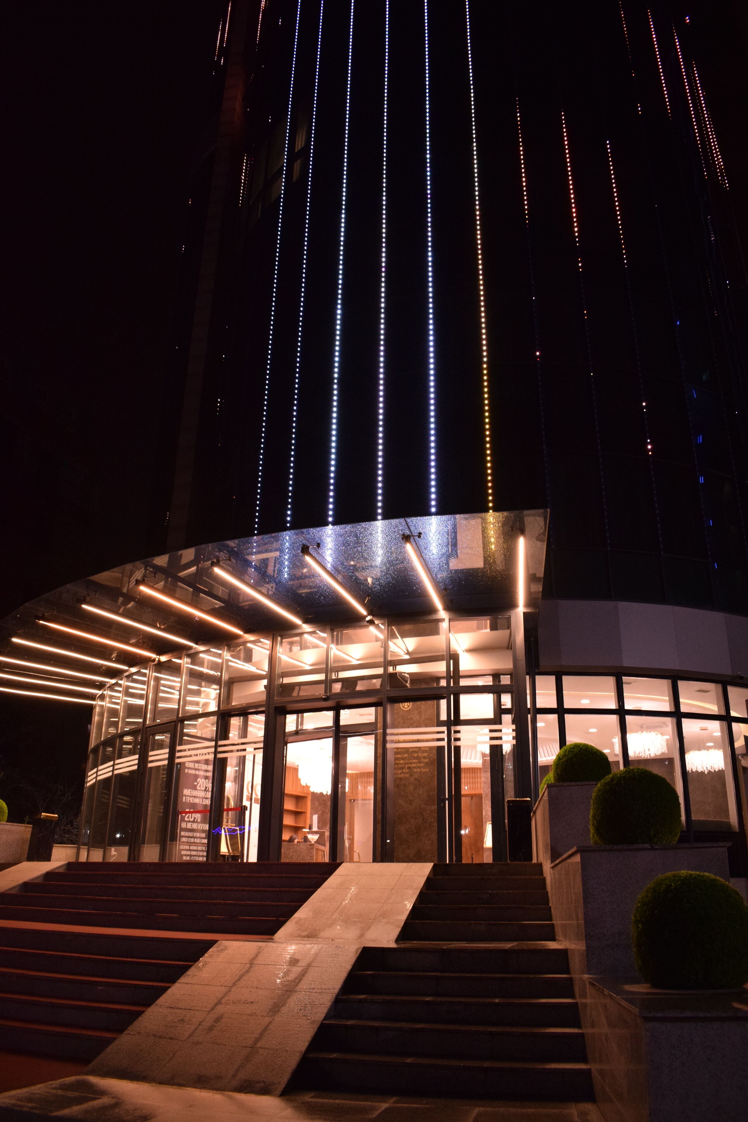 Um edifício moderno com fachada de vidro e uma série de faixas verticais de luz.