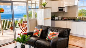 Uma sala de estar moderna com um sofá de couro, uma mesa de centro e vista para o mar.