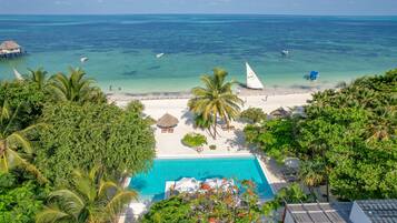 Um resort com piscina, praia e vista para o oceano.