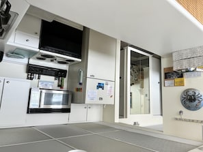 Uma cozinha compacta com micro-ondas, fogão e frigorífico.