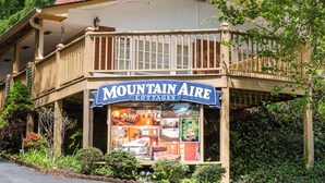 Um edifício de dois andares com uma varanda e uma placa que diz 'Mountain Aire Cottages'.