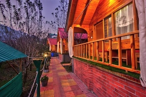Uma cabana de madeira com varanda coberta e fachada de tijolos.