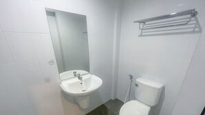 Um banheiro com pia branca, vaso sanitário e espelho.