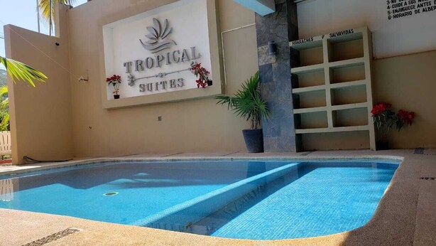 Uma área de piscina com uma placa indicando 'Tropical Suites'.