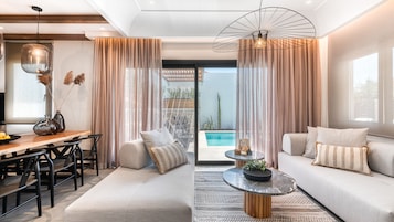 Sala moderna com sofá, mesa de jantar e cadeiras, vista para piscina e luminária pendente.