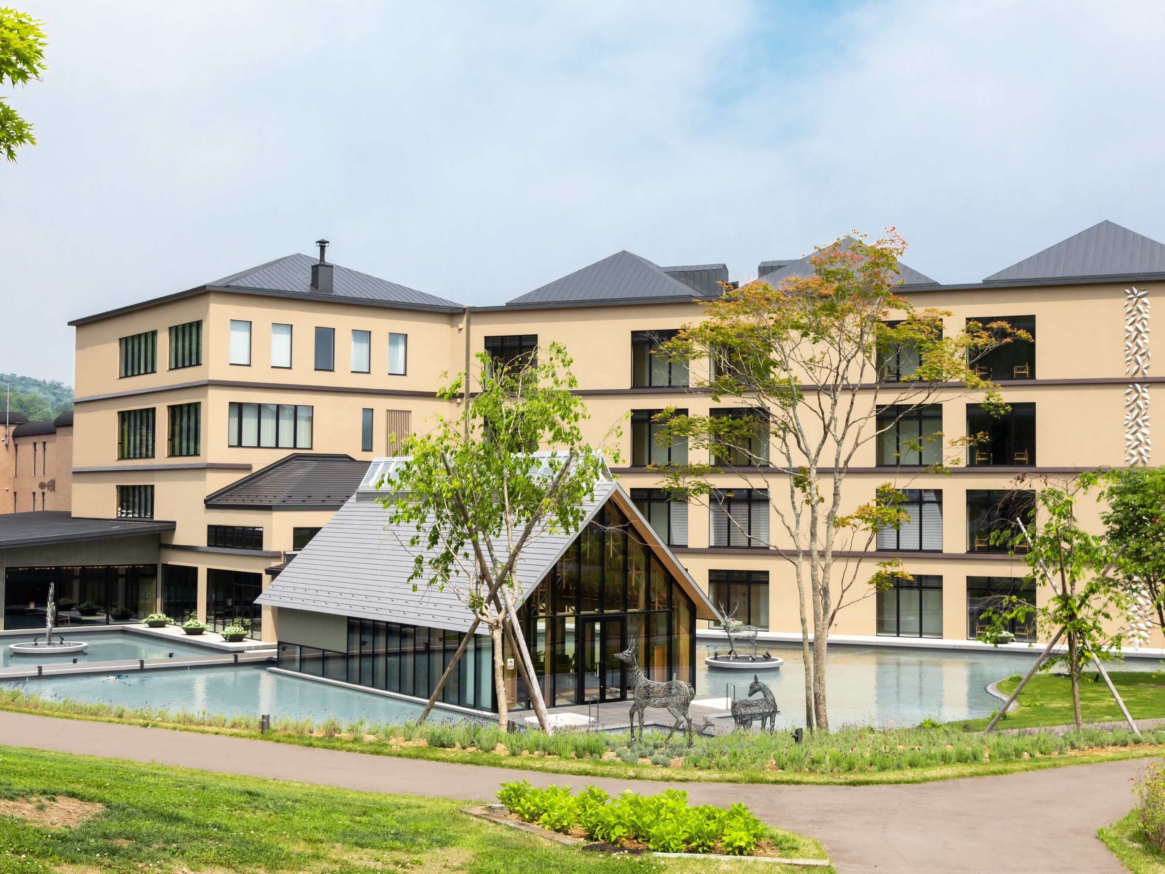 Um edifício moderno com vários andares, um pátio central com piscina e áreas de estar ao ar livre.