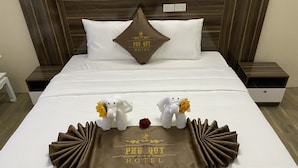 Cama arrumada com uma toalha marrom e um travesseiro com o logotipo 