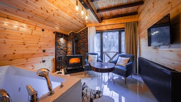 Quarto Deluxe, lareira, vista para a montanha | Sala de estar | Televisor LED de 55 polegadas com canais via satélite, televisor