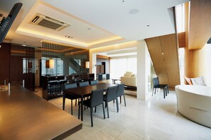 Uma sala de estar moderna com área de jantar, cozinha e escada.