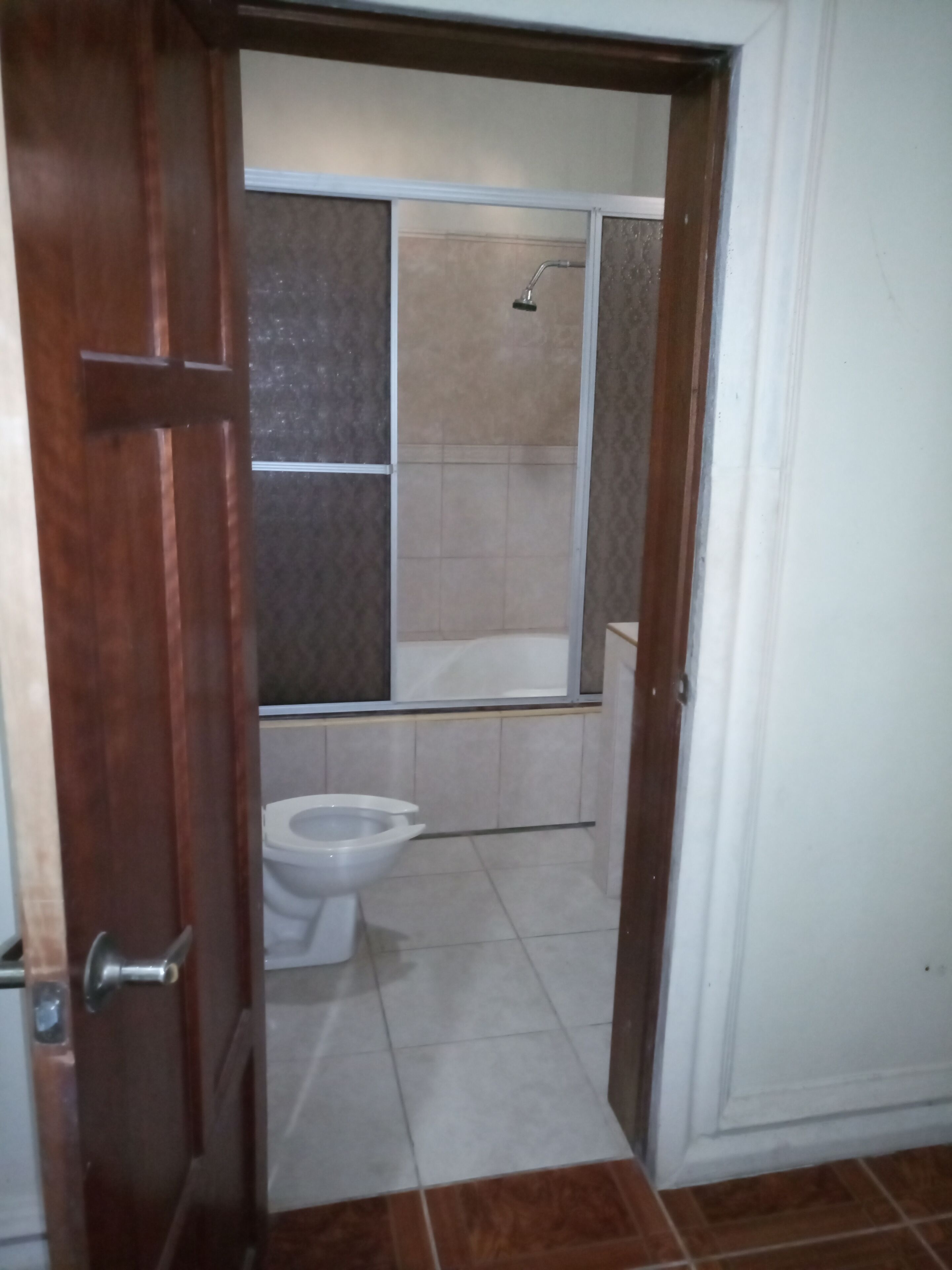 Uma casa de banho com sanita, chuveiro e banheira.