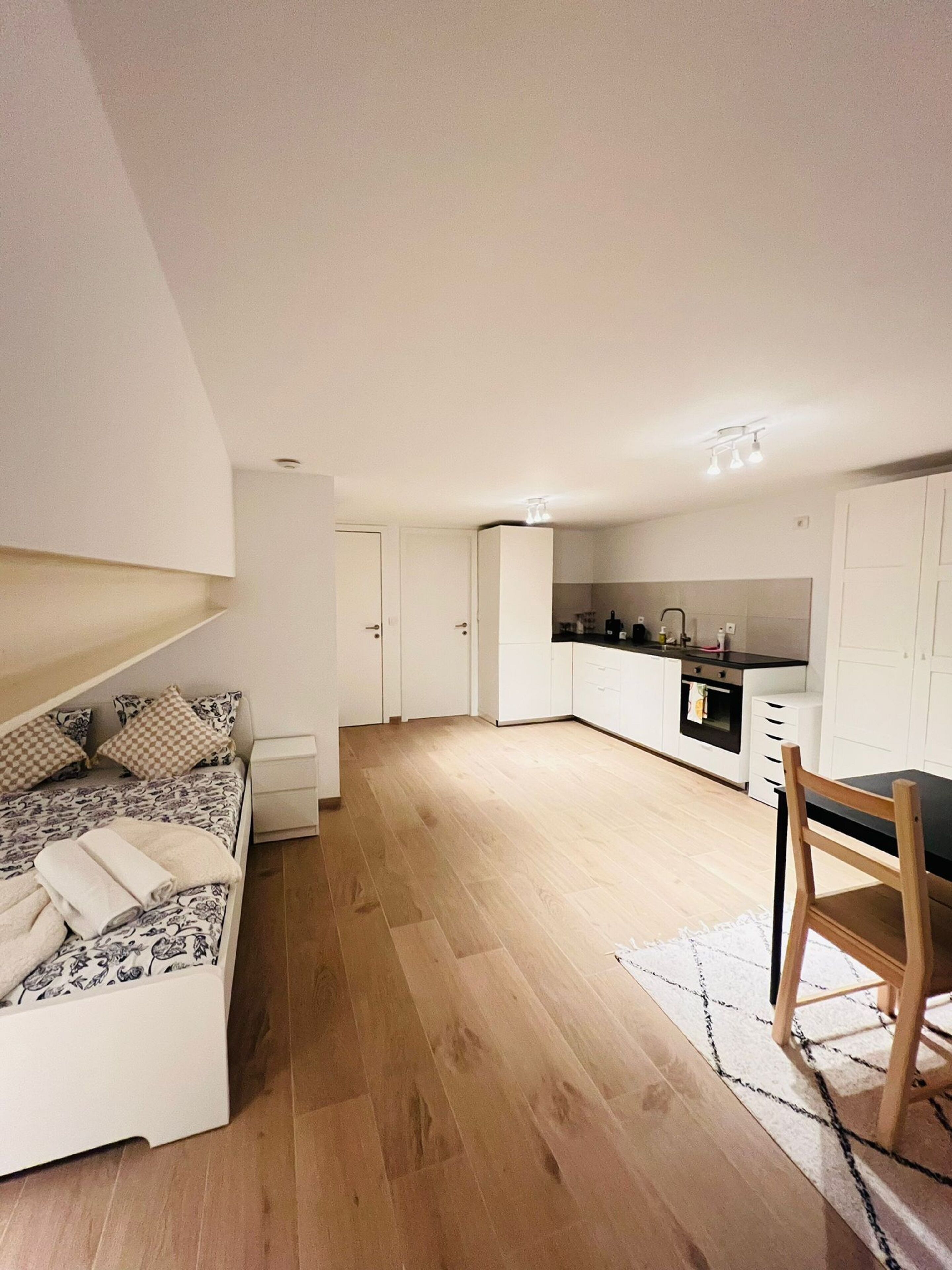 Um apartamento moderno com cozinha, sala de jantar e quarto.