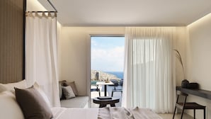 Quarto de hotel moderno com cama, área de estar com vista e varanda com mesa e cadeiras.
