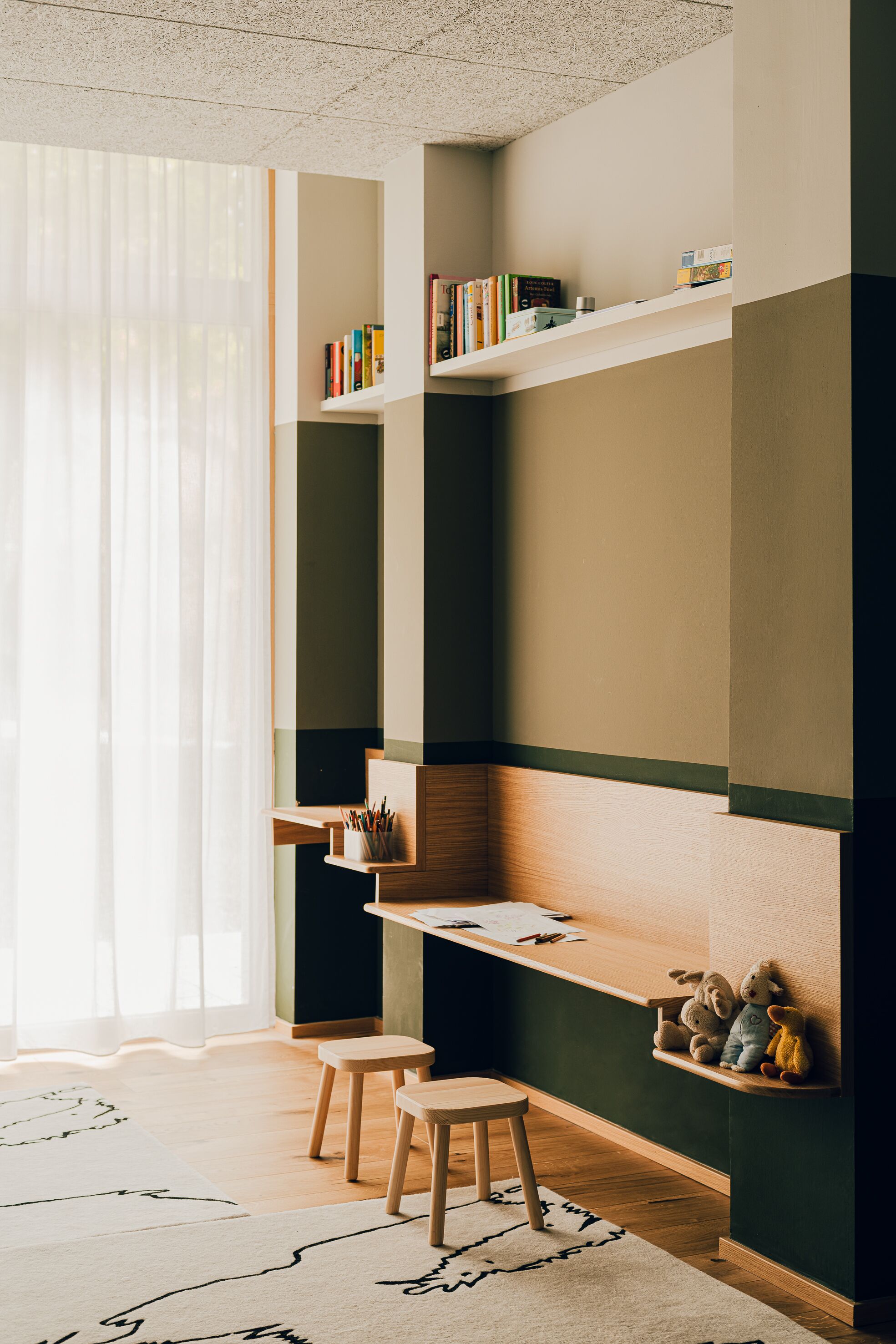 Quarto moderno com escrivaninha de madeira, dois bancos, uma estante e um tapete.