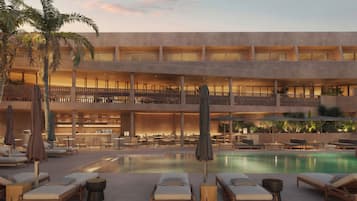 Um hotel com vários níveis, área de piscina, espreguiçadeiras e bar.