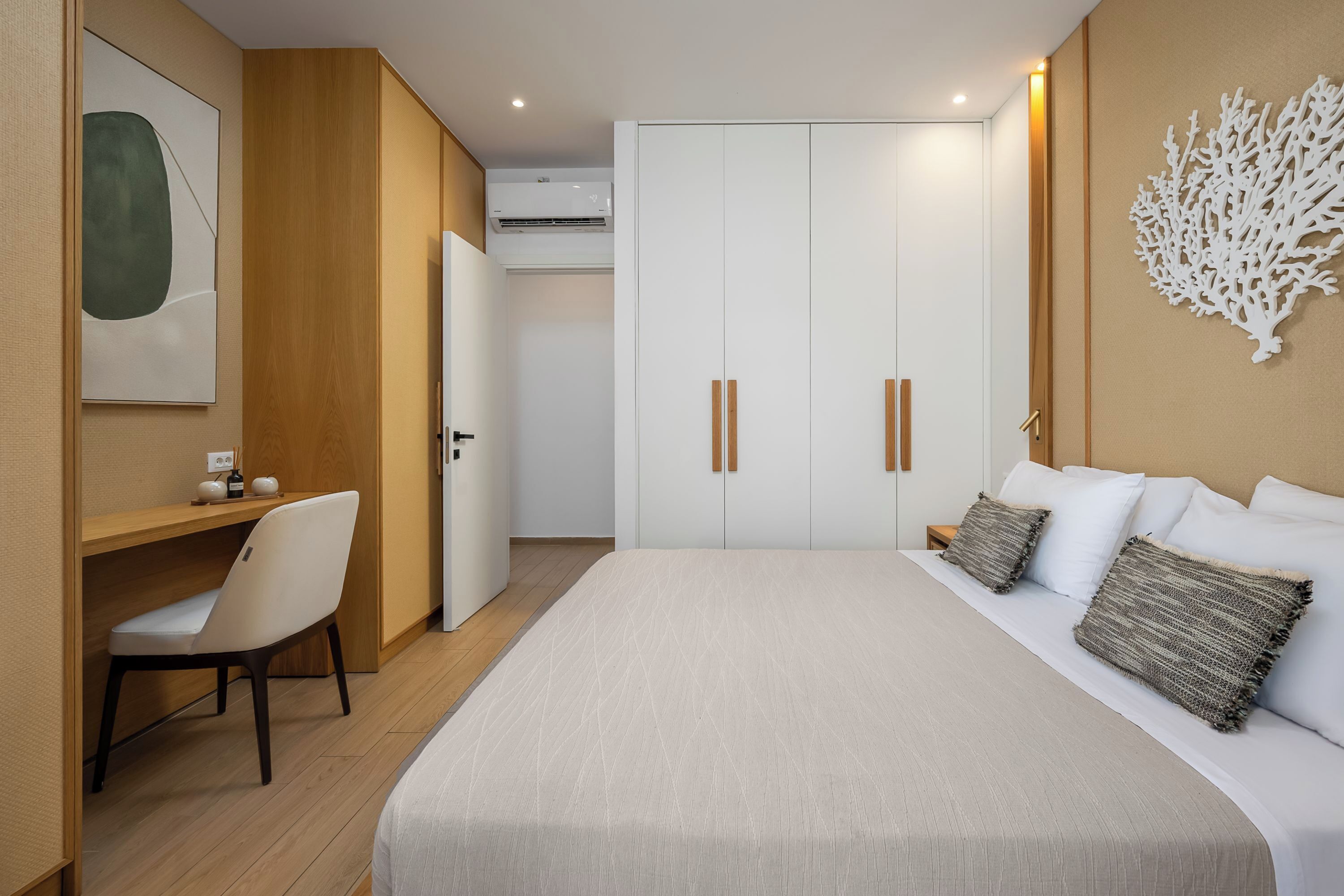 Quarto com uma cama, escrivaninha, cadeira e guarda-roupa.