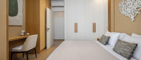 Quarto com uma cama, escrivaninha, cadeira e guarda-roupa.