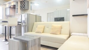 Uma sala de estar moderna com sofá, mesa de centro e geladeira.