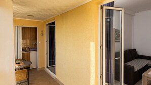 Um espaço compacto com cozinha compacta, área de refeições e sala de estar com sofá e mesa.