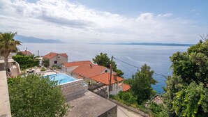 Uma área residencial costeira com casas, piscina e vista para o mar.