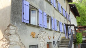 Um edifício com várias janelas, uma escadaria e uma porta.
