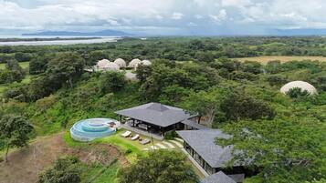 Um resort com piscina, espreguiçadeiras e vista para a paisagem ao redor.