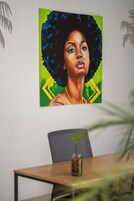 Pintura de uma pessoa com um penteado afro volumoso em uma parede.