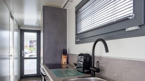 Uma cozinha moderna com uma pia de aço inoxidável, uma torneira preta, uma torradeira e um porta-facas.