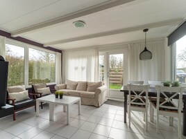 Uma sala de estar espaçosa com sofá, mesa de centro e área de jantar.