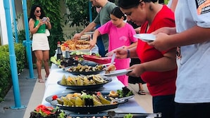 Uma mesa de buffet com diversos pratos, incluindo frutos do mar, saladas e petiscos.