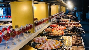 Buffet com diversos doces e bebidas.
